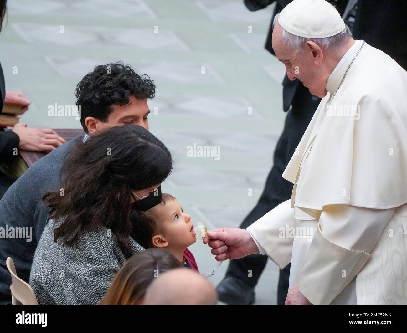 Pope Francis takes the pacifier of a baby during his weekly general ...