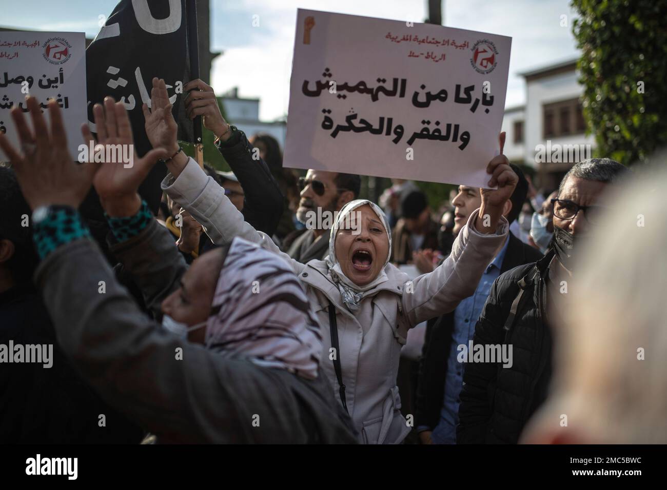 A woman chants slogans and holds a banner as people protest against ...