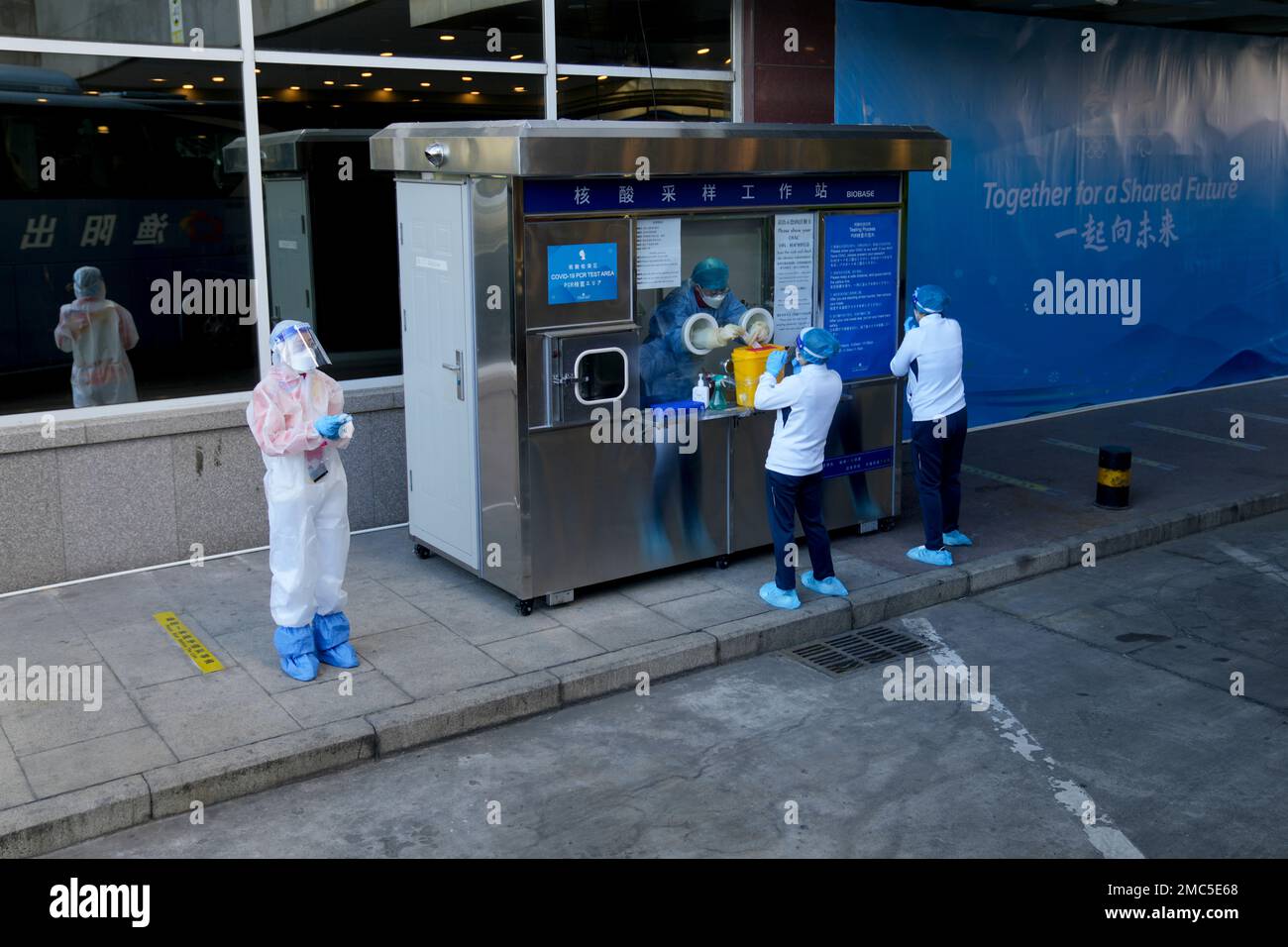 FILE - A worker performs a COVID-19 test at the 2022 Winter Olympics ...