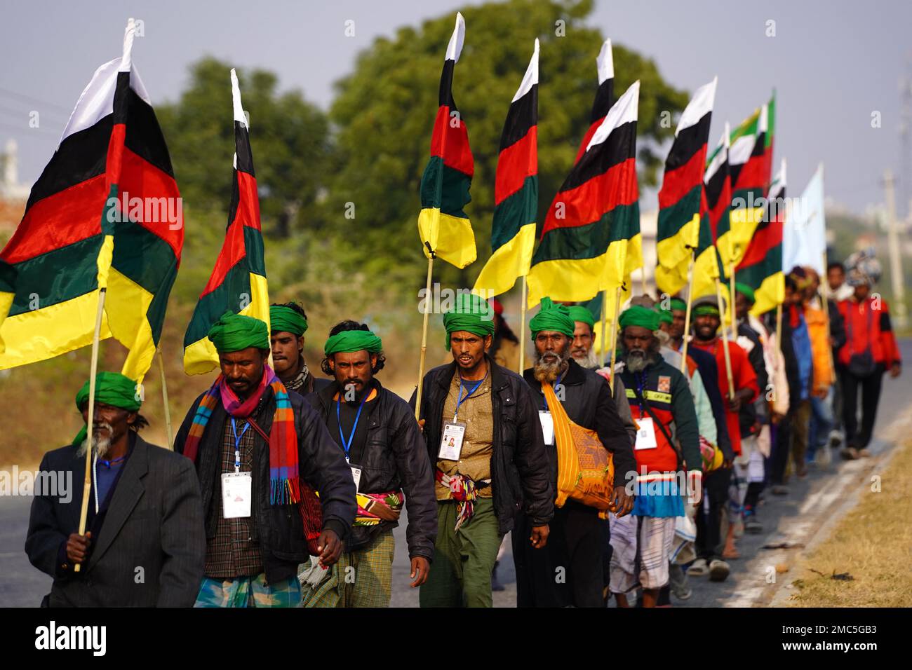 Muslim devotees carrying religious flags walk along a road as they ...