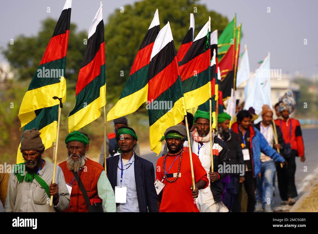Muslim devotees carrying religious flags walk along a road as they ...