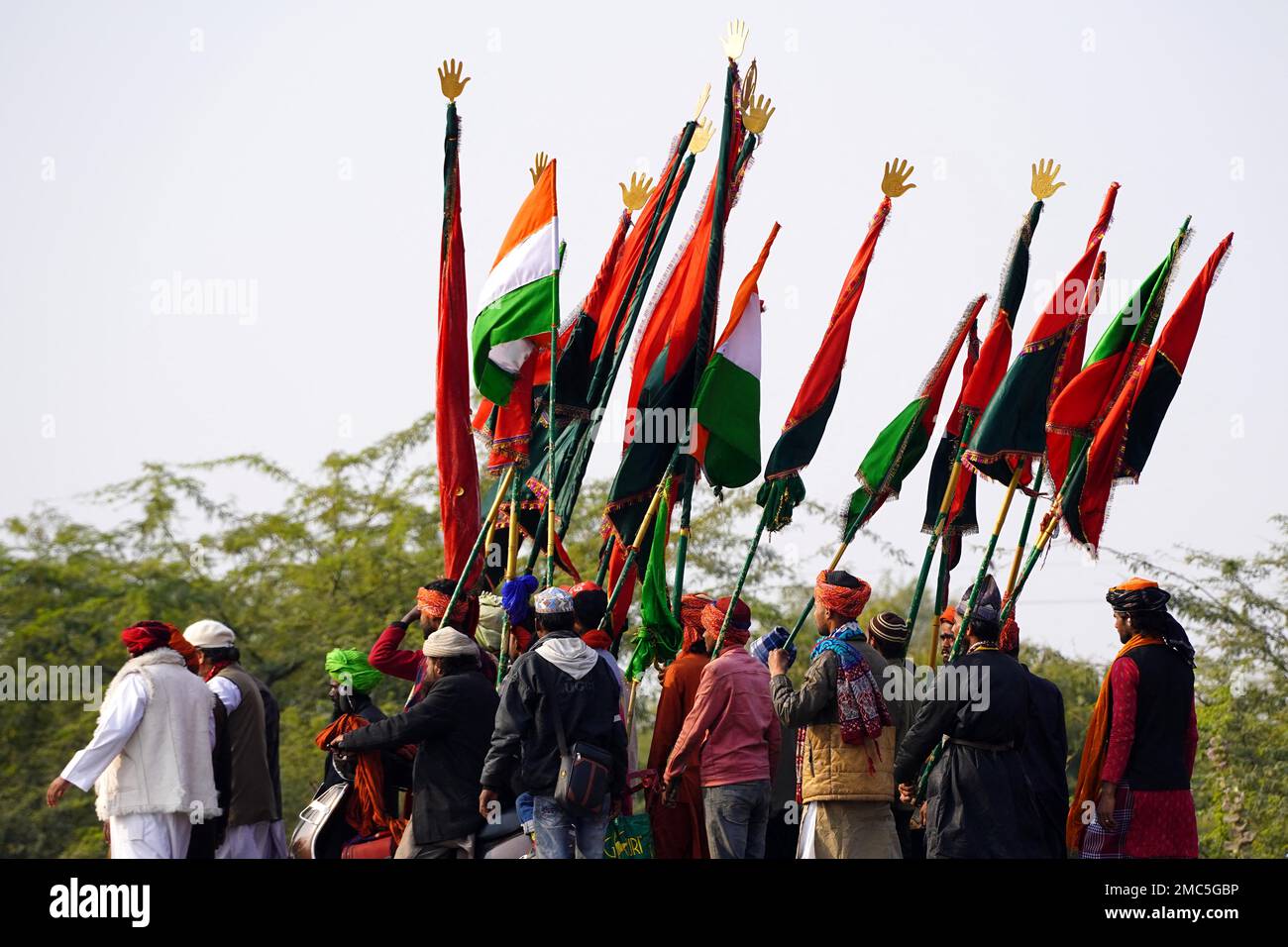 Muslim devotees carrying religious flags walk along a road as they ...