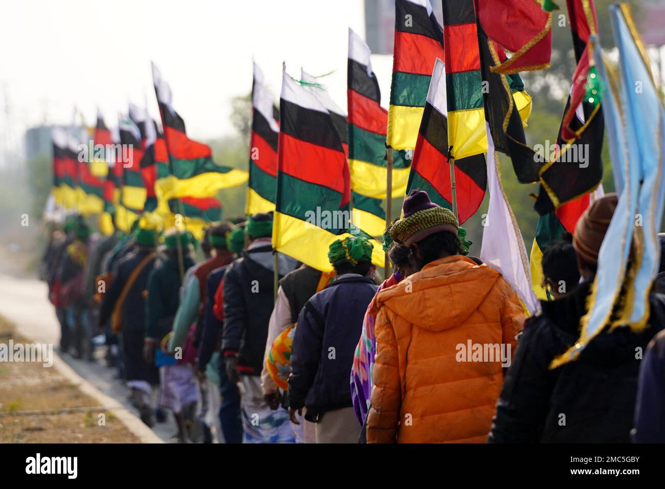 Muslim devotees carrying religious flags walk along a road as they ...