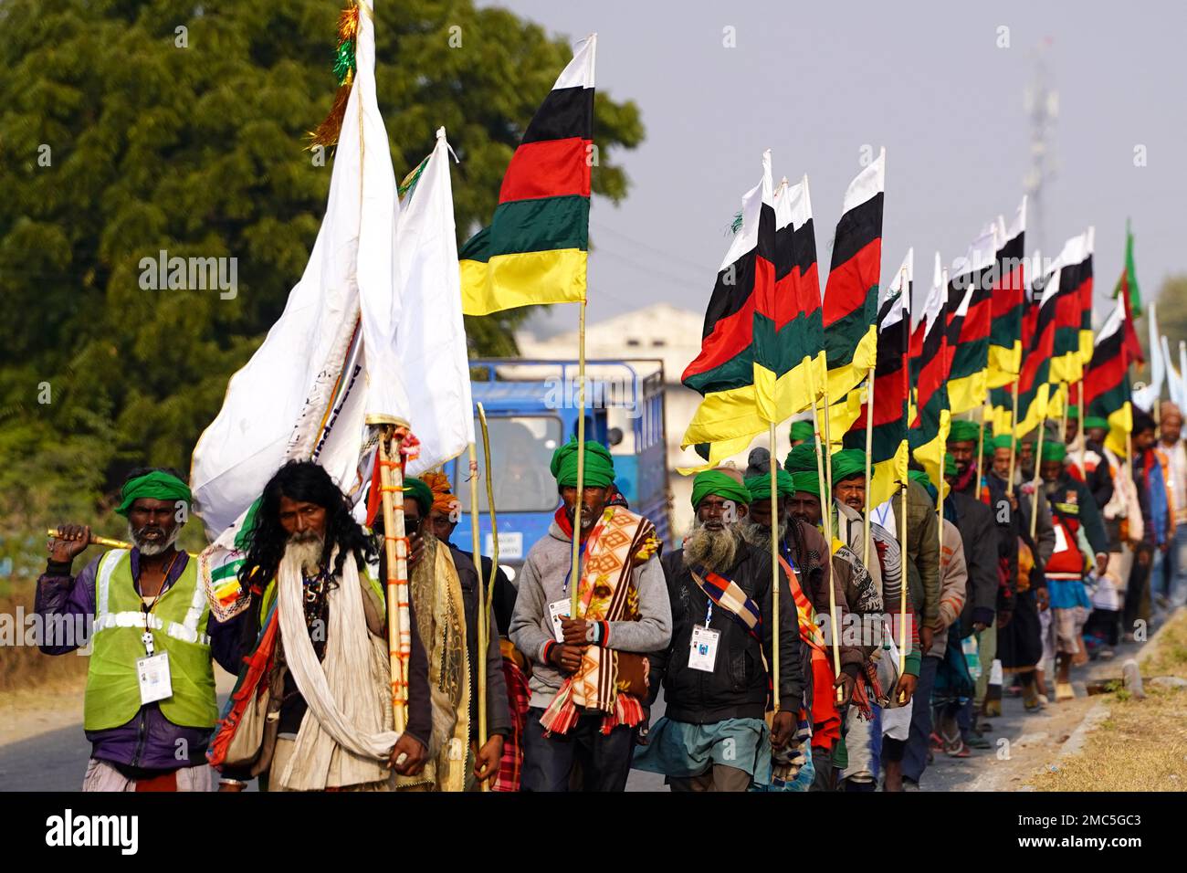 Muslim devotees carrying religious flags walk along a road as they ...