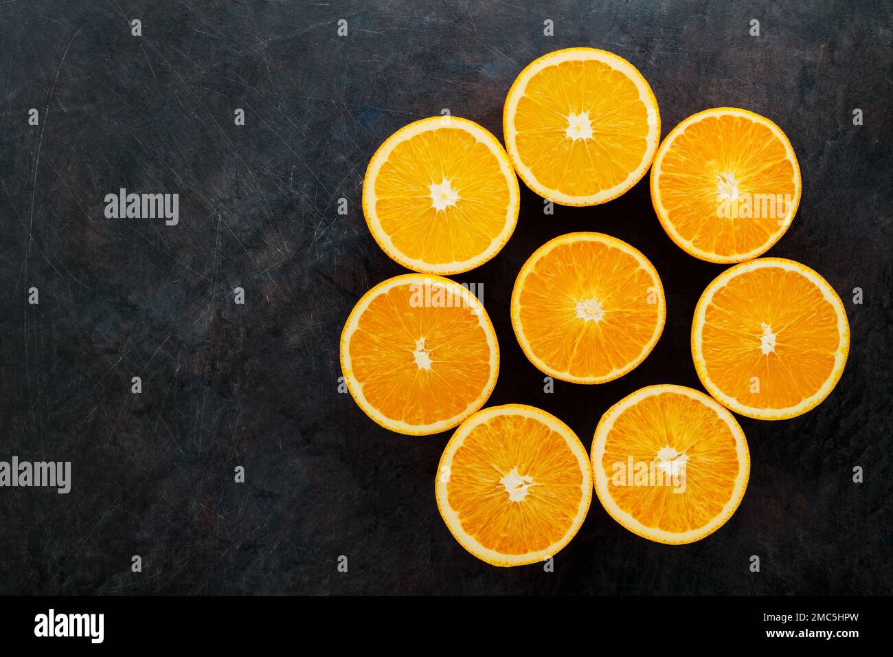 Halves of ripe oranges on a dark background. Sliced oranges for ...