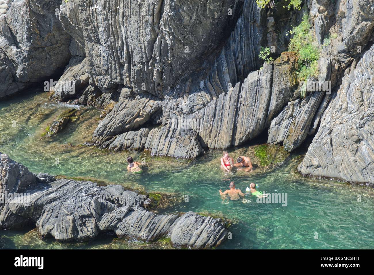 Tourists to Manarola beach bay, they bathe in the middle of the granite ...