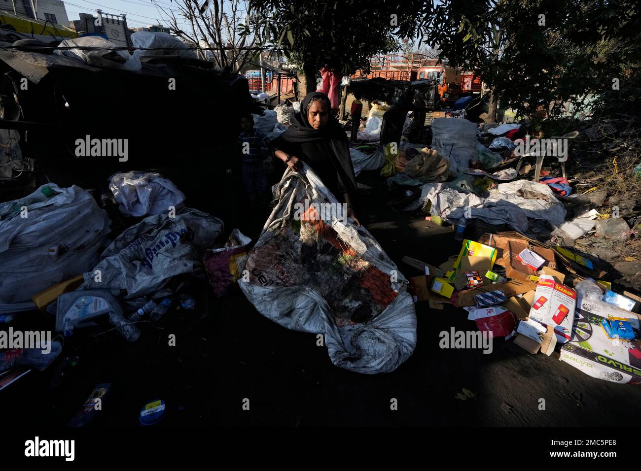 An Indian rag picker collects recyclable material at a junkyard on the ...