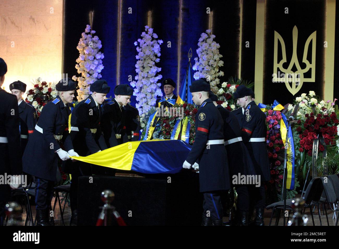 KYIV, UKRAINE - JANUARY 21, 2023 - Honour guards cover a coffin with a ...