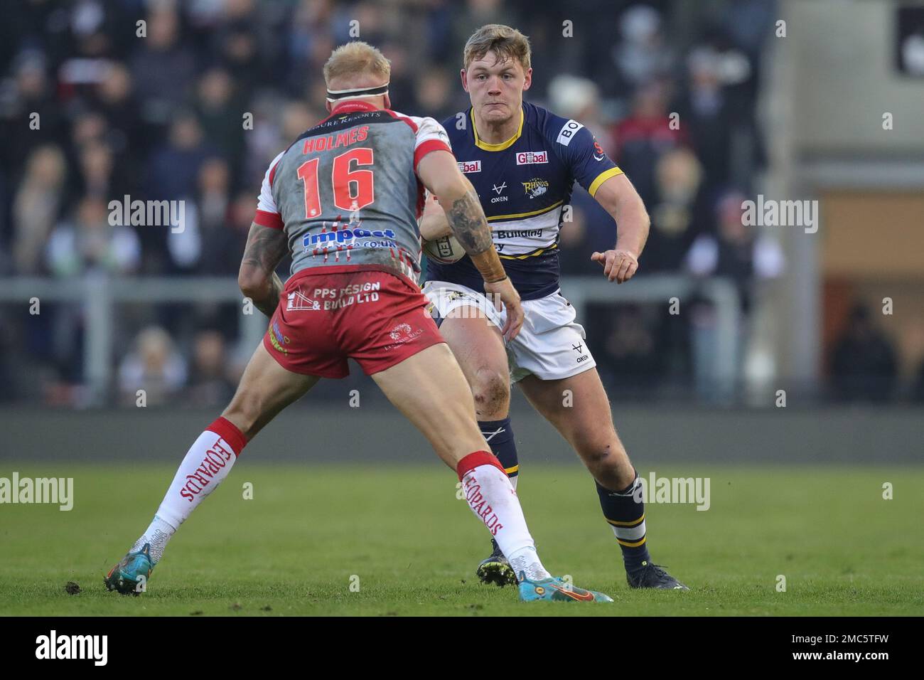James McDonnell #19 of Leeds Rhinos is tackled by Oliver Holmes #16 of ...