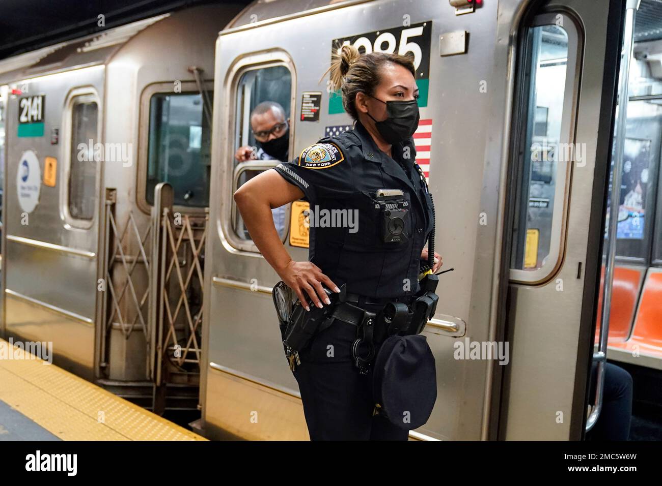 FILE - A New York City Police Department officer and a subway conductor ...