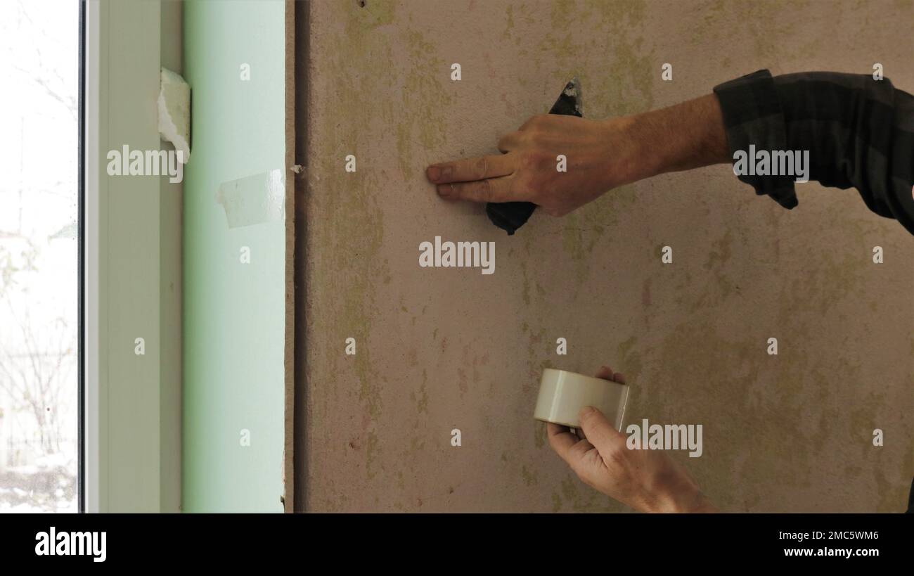 fastening with adhesive tape a chipboard sheet to a window slope fixed ...