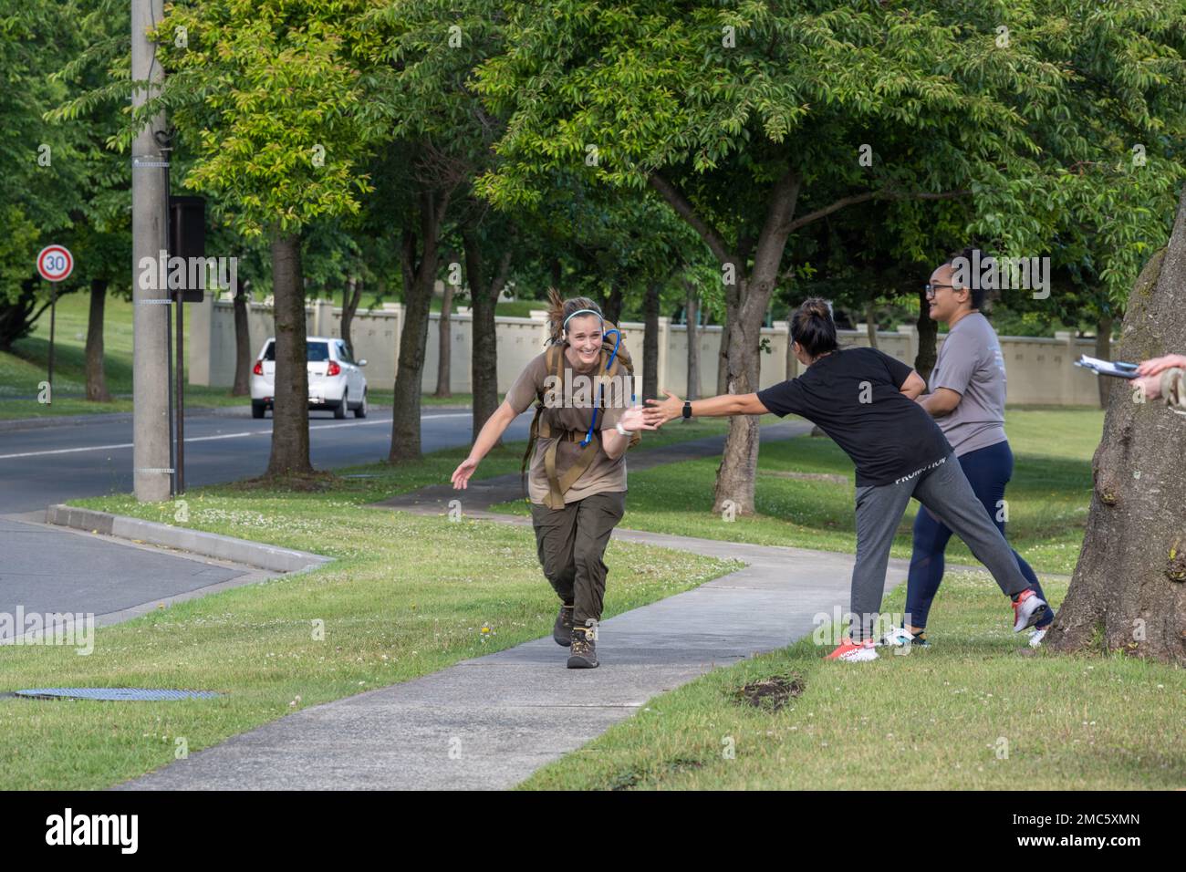 Volunteers congratulate a participant at the finish line during a ...