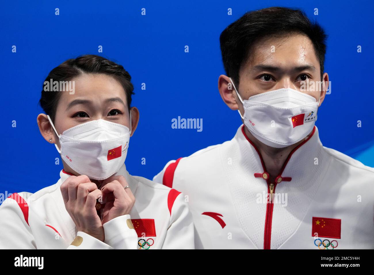 Peng Cheng and Jin Yang, of China, react after the pairs short program ...