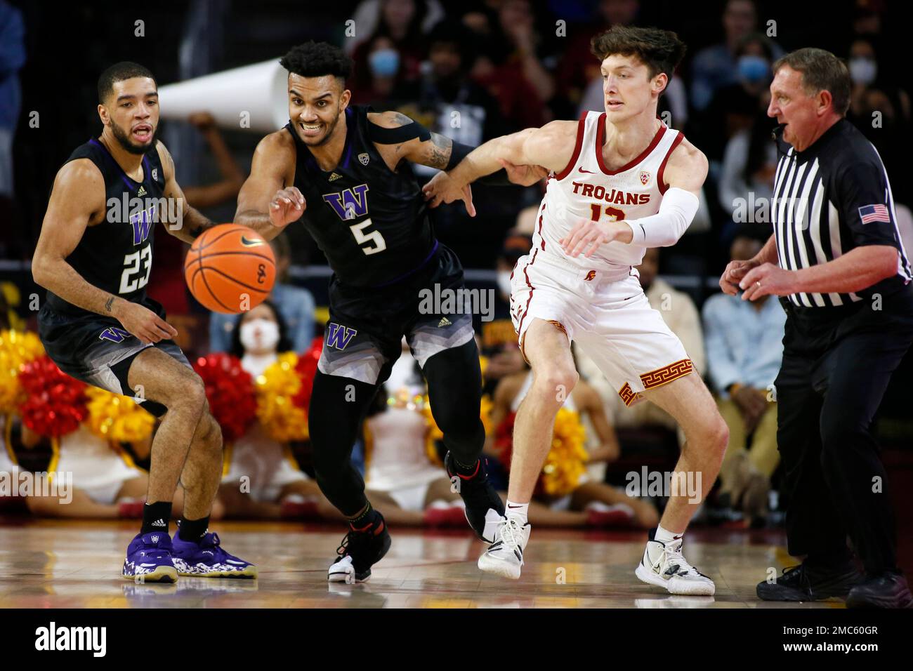 Washington guard Jamal Bey, center, attempts to steal the ball from ...