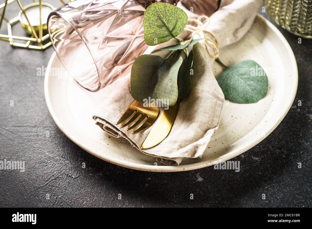 White craft plate, cutlery and green plants at black table Stock Photo ...