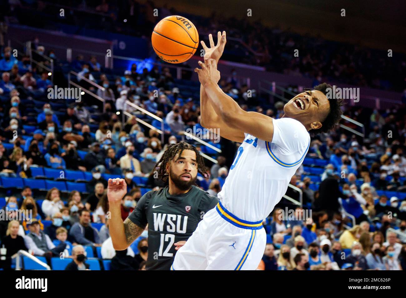 UCLA guard Jaylen Clark, right, is fouled after driving past Washington ...