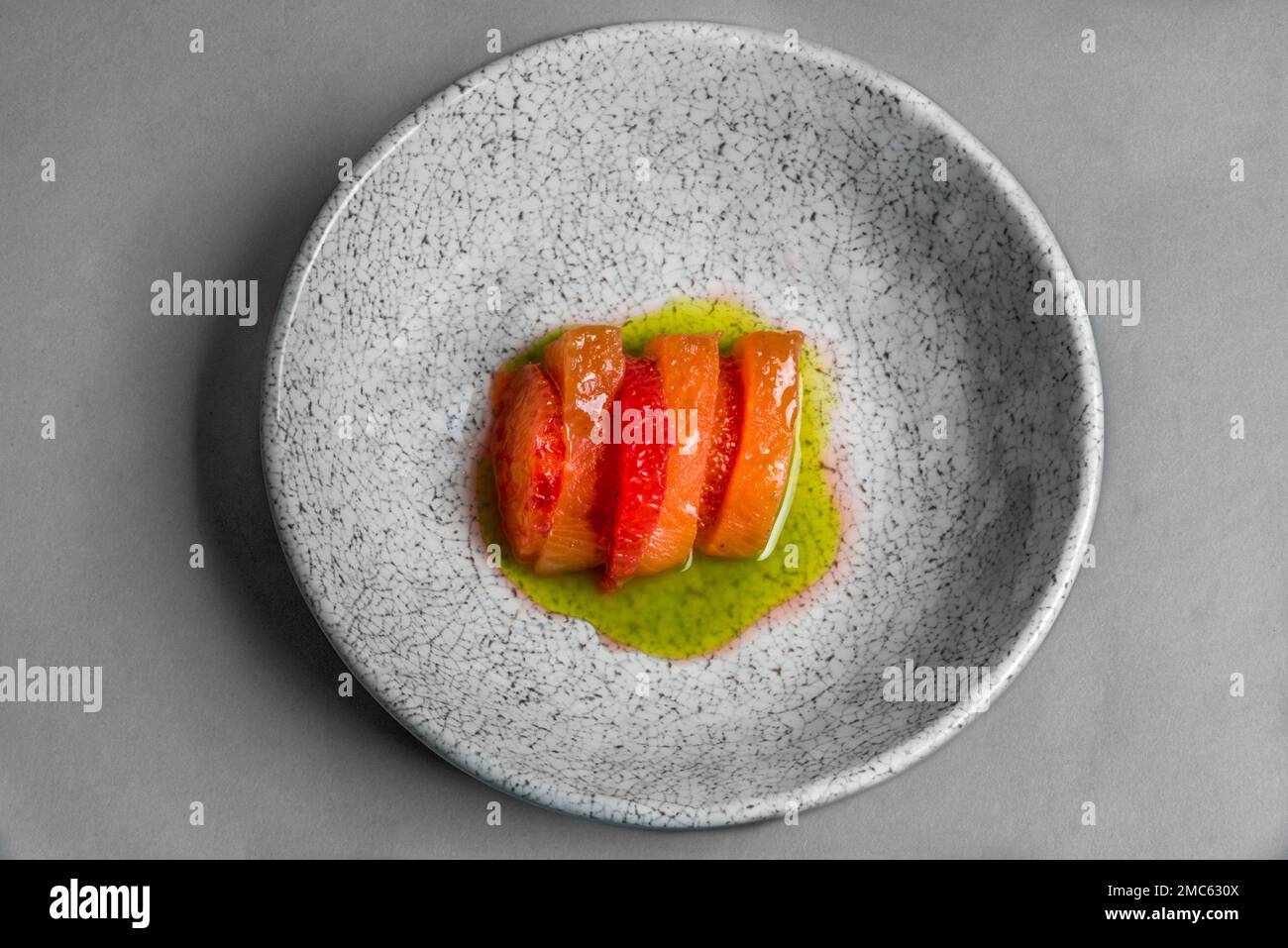 A Birdseye view of a modern plated meal, shot against a plain grey ...