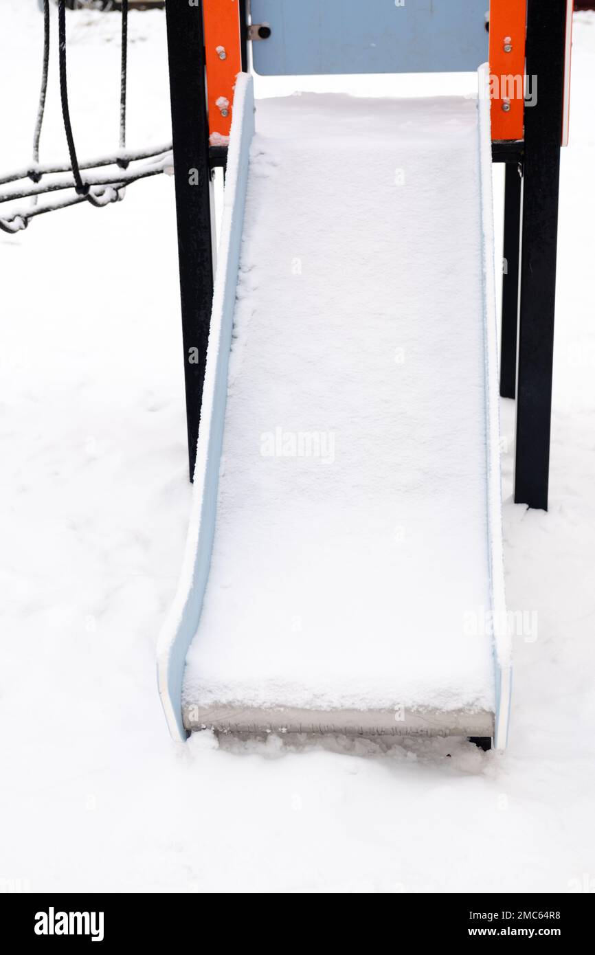 snow-covered empty slide on the street, on the playground Stock Photo ...