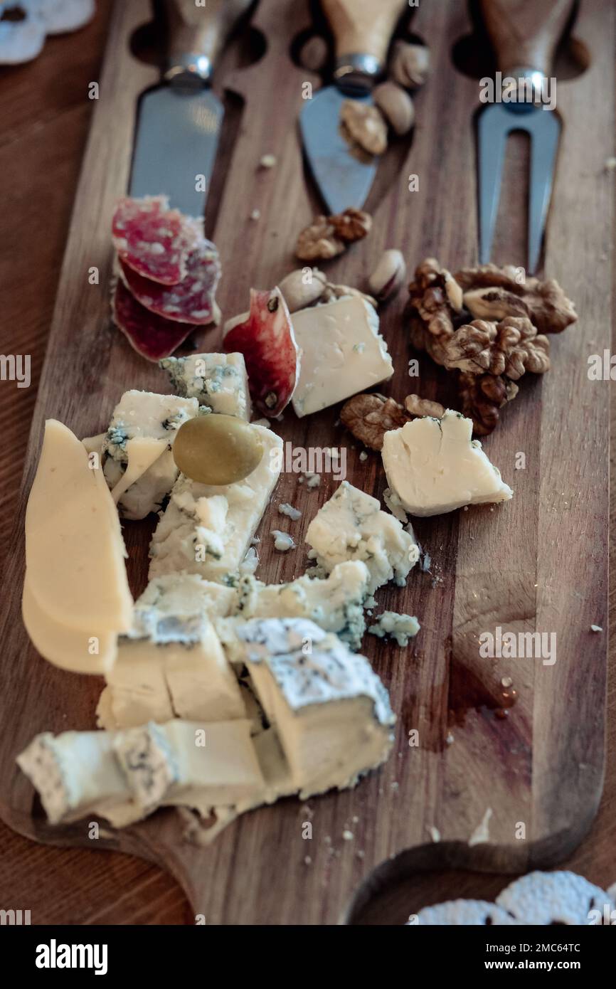 cheese plate with different types, with walnuts and tasting devices ...