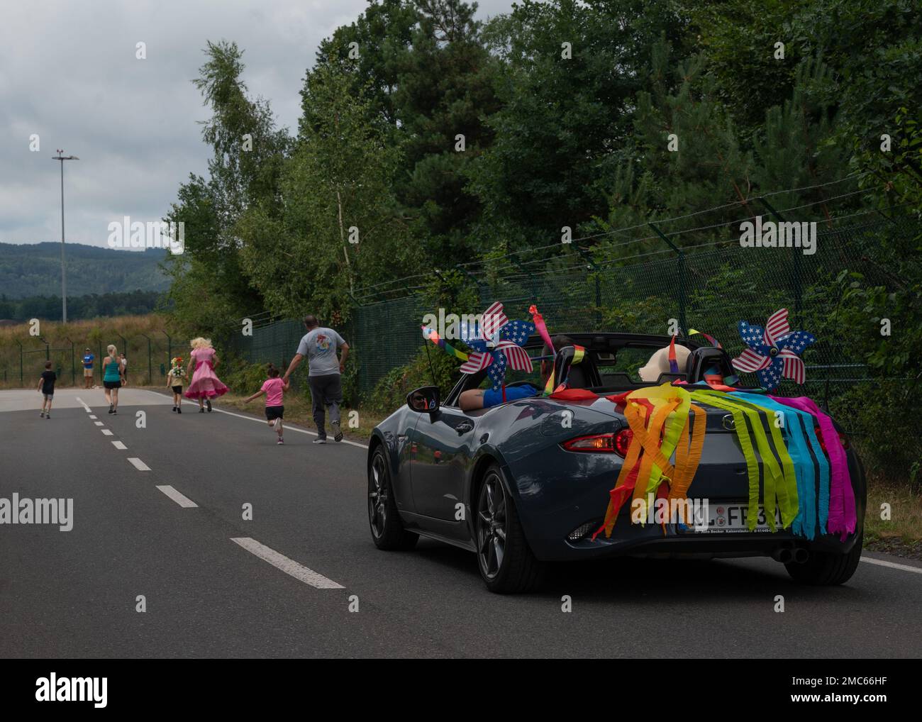 A trail car follows runners during the first annual Pride Month 5K ...