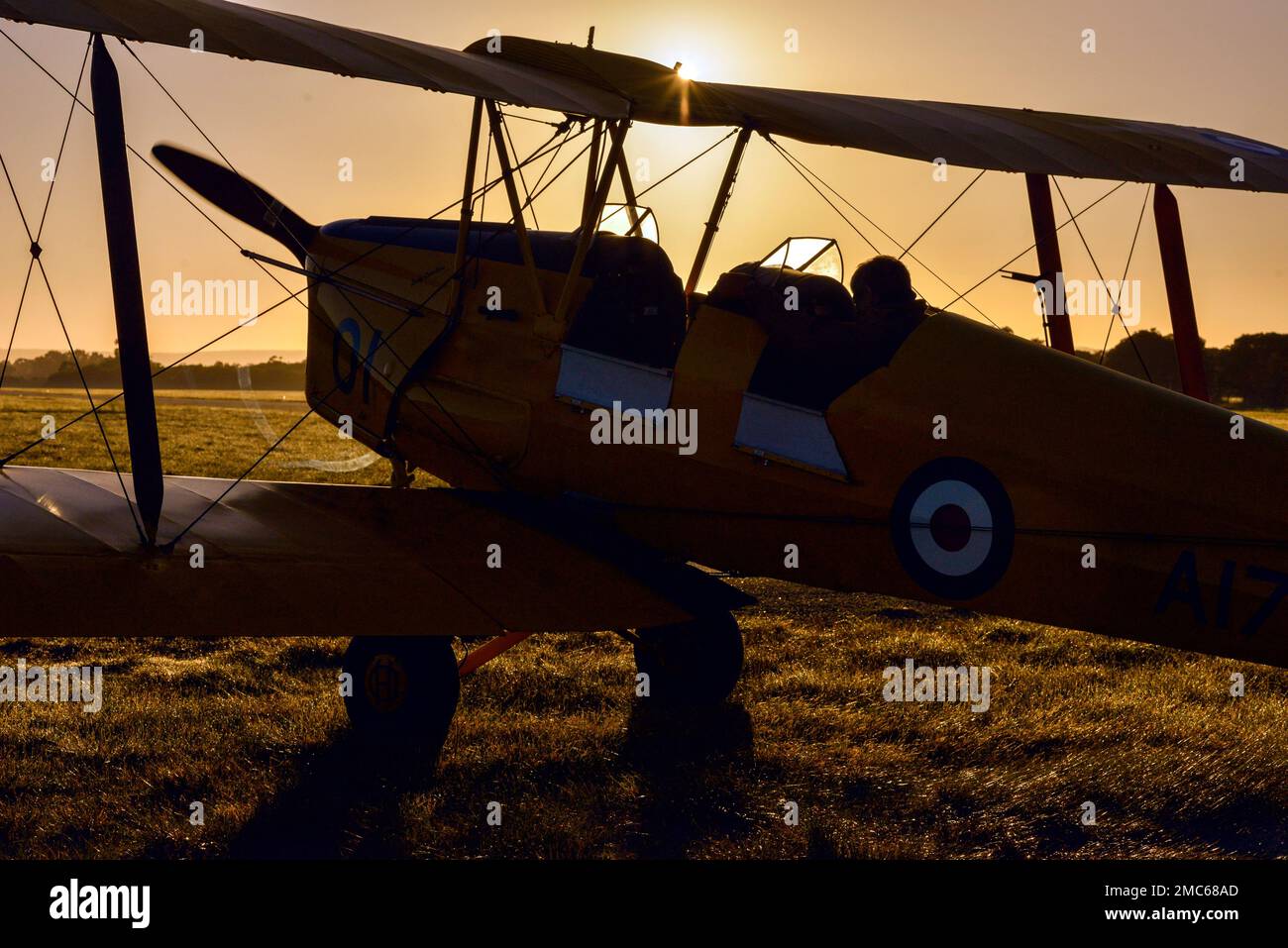 A silhouette of a 1930's DH82 Tiger Moth biplane at sunrise Stock Photo ...