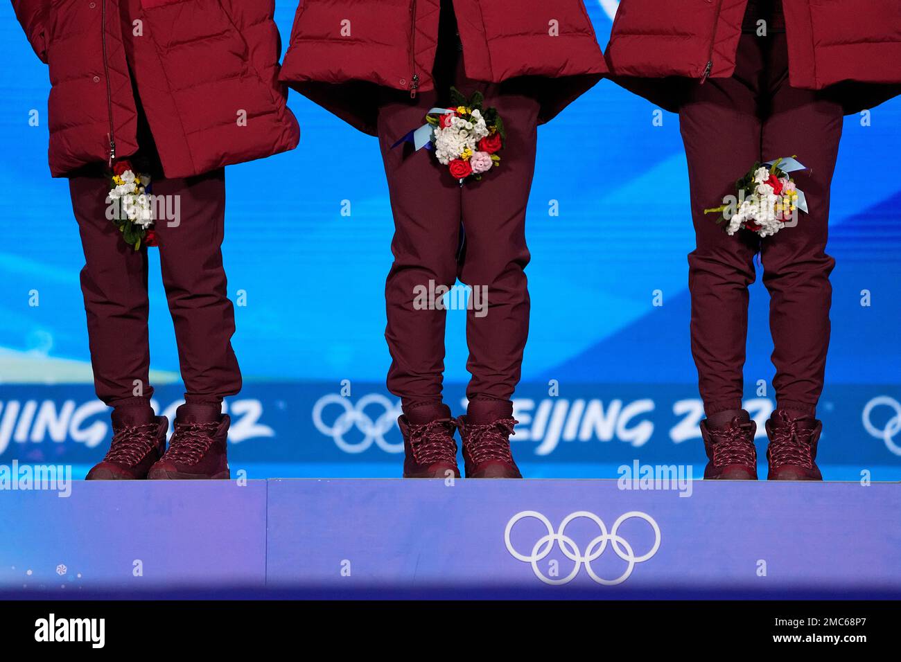 Canadian athletes prop their bouquets between their legs to wear their ...
