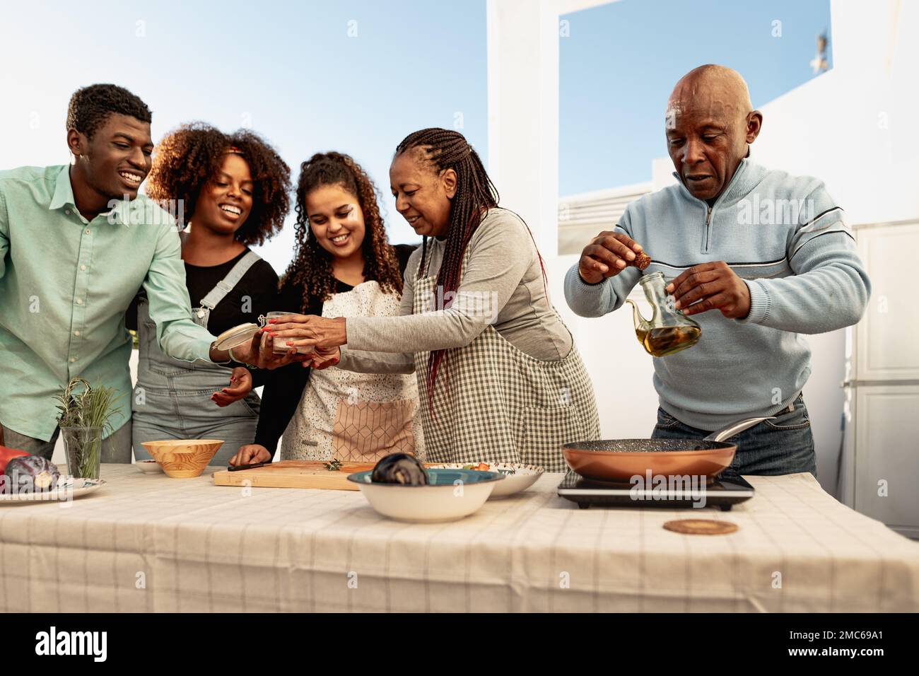 Happy African family preparing a dinner together on house patio Stock ...