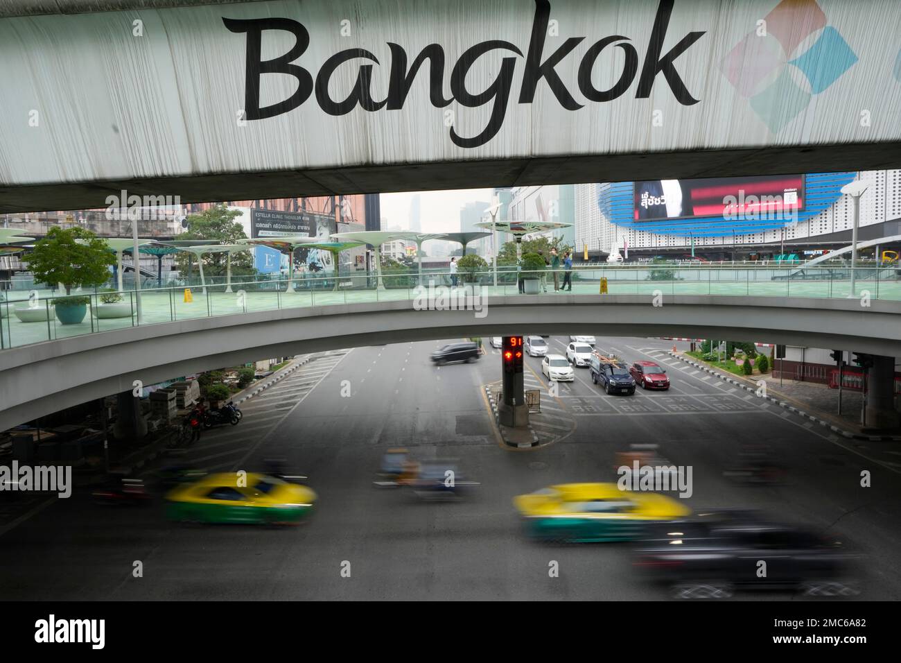 Vehicles run on the road under the "Bangkok" signage on the sky train ...