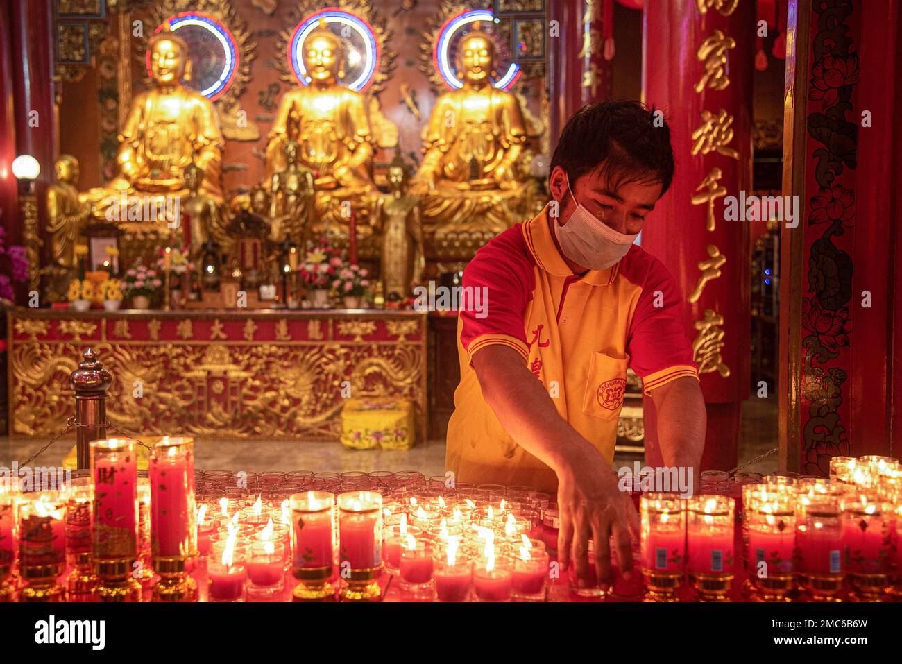 A Chinese temple's staff sets up the candles at the Chinese temple ...