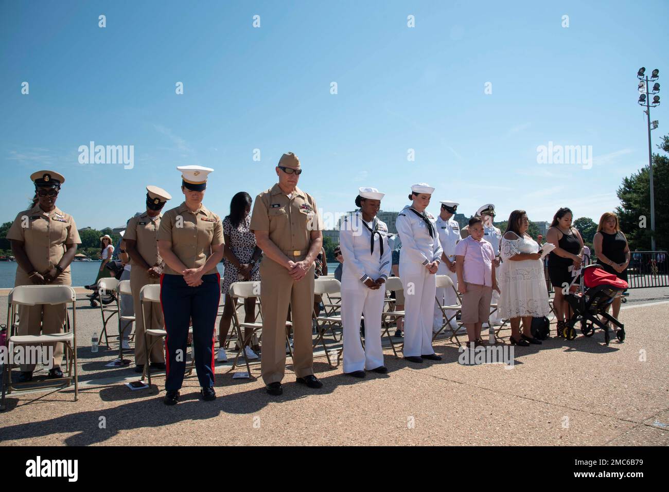 Attendees bow their heads during the invocation of a commissioning ...