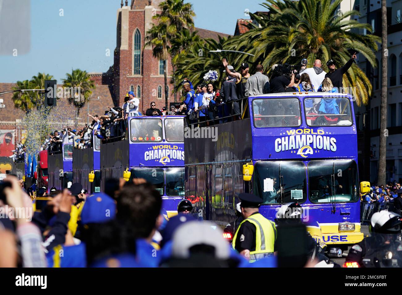 Buses carrying Los Angeles Rams players and coaches drive past fans ...