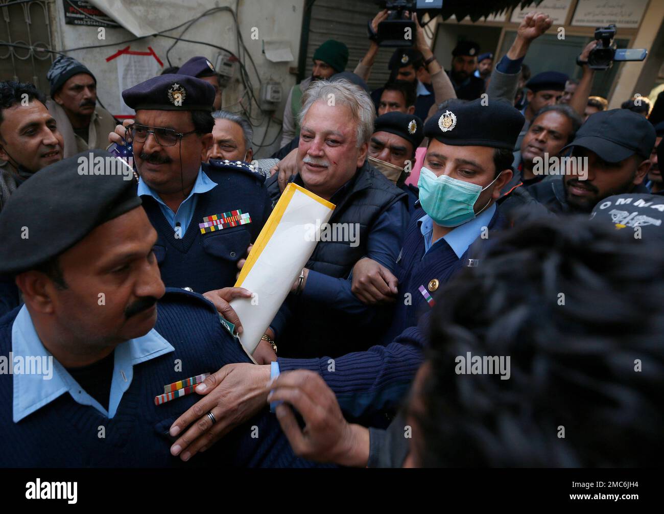 Police officers escort Pakistani journalist Mohsin Baig, center, for ...
