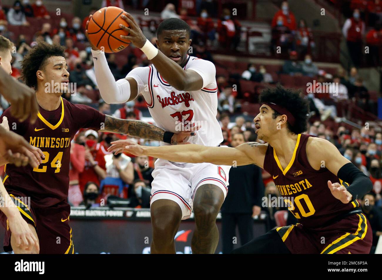 Ohio State's E.J. Liddell, center, tries to drive between Minnesota's ...