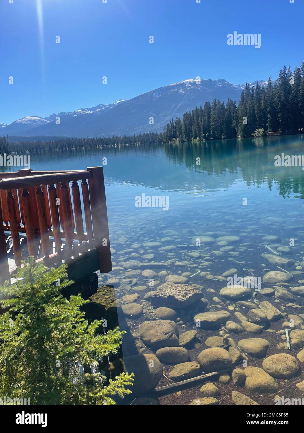 A clear blue lake with the reflection of the trees in the water Stock ...