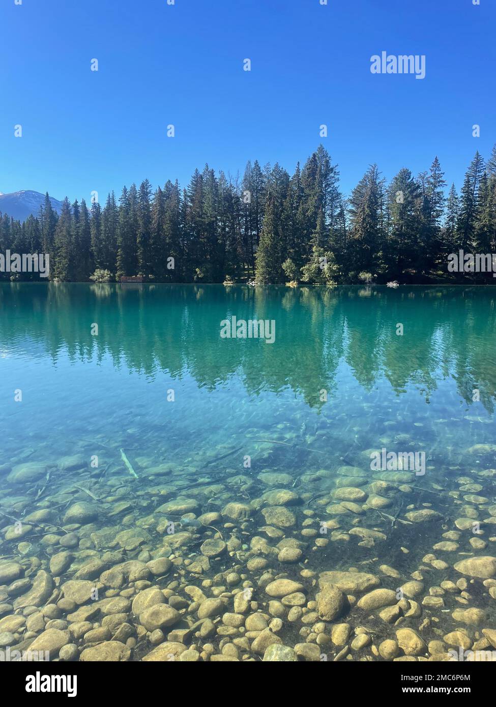 A clear blue lake with the reflection of the trees in the water Stock ...