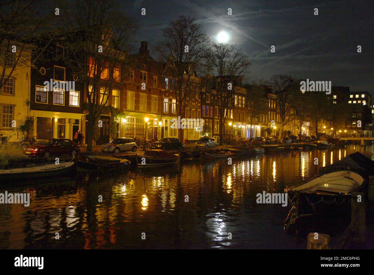Night time view of a canal in Amsterdam with lights reflected in the ...