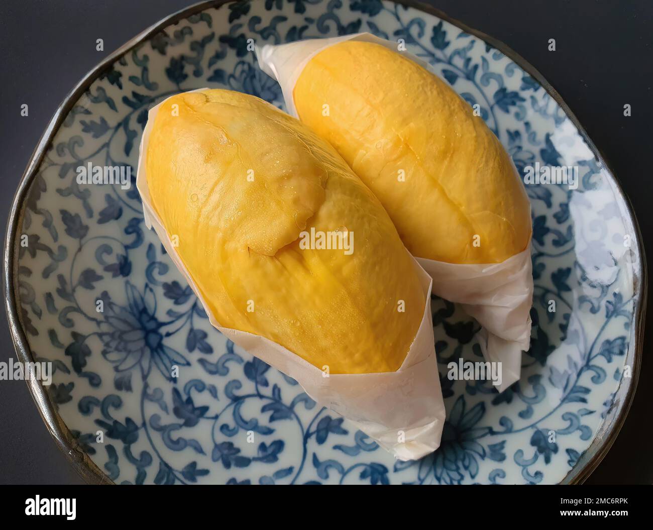 Two of Golden yellow color Durian meat wrapped with white paper on the ...