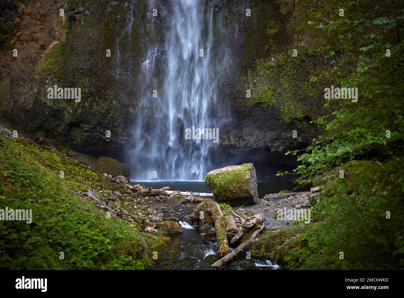A raging waterfall surrounded by rocks Stock Photo - Alamy