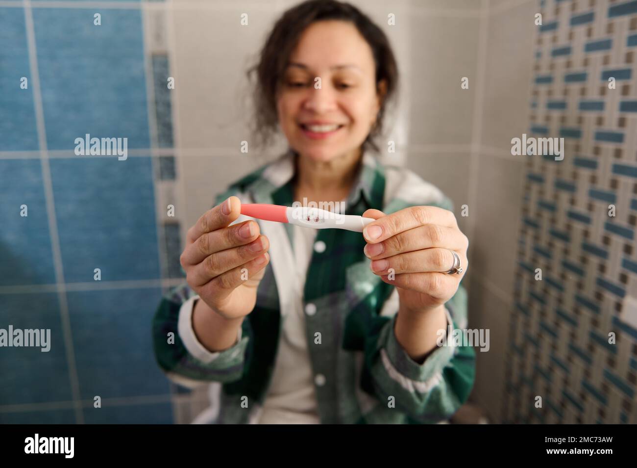 Blurred woman takes pregnancy test, rejoices at positive result and ...