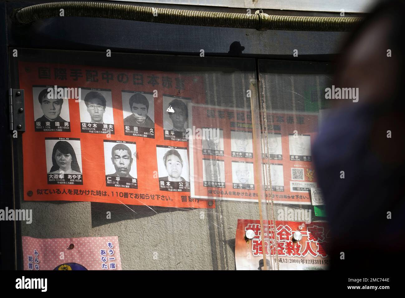 A man walks past a poster of wanted persons and how they might look in ...