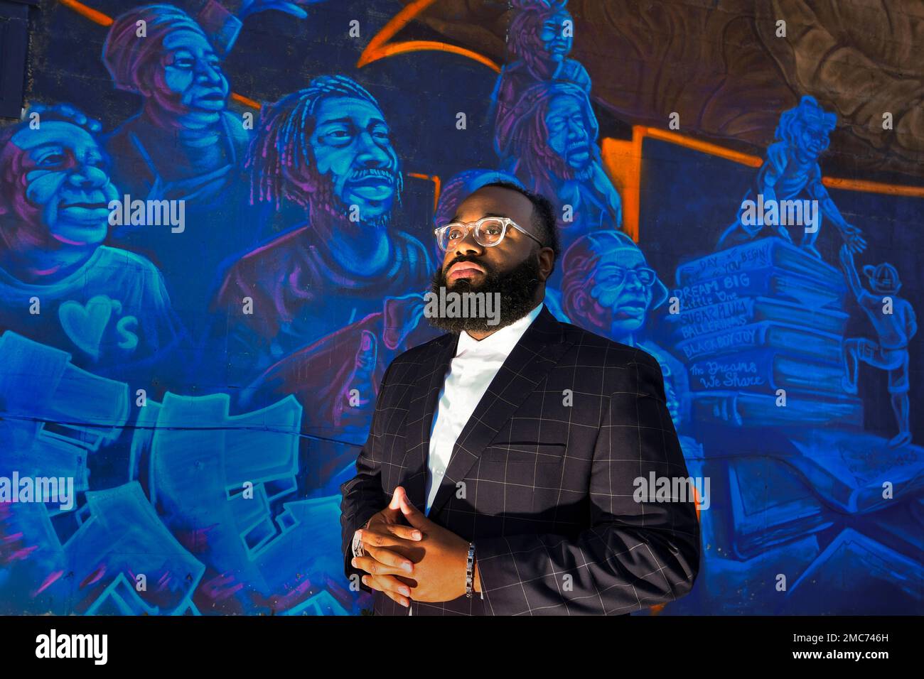Pastor Aaron Marble stands in front of a mural in the historically ...