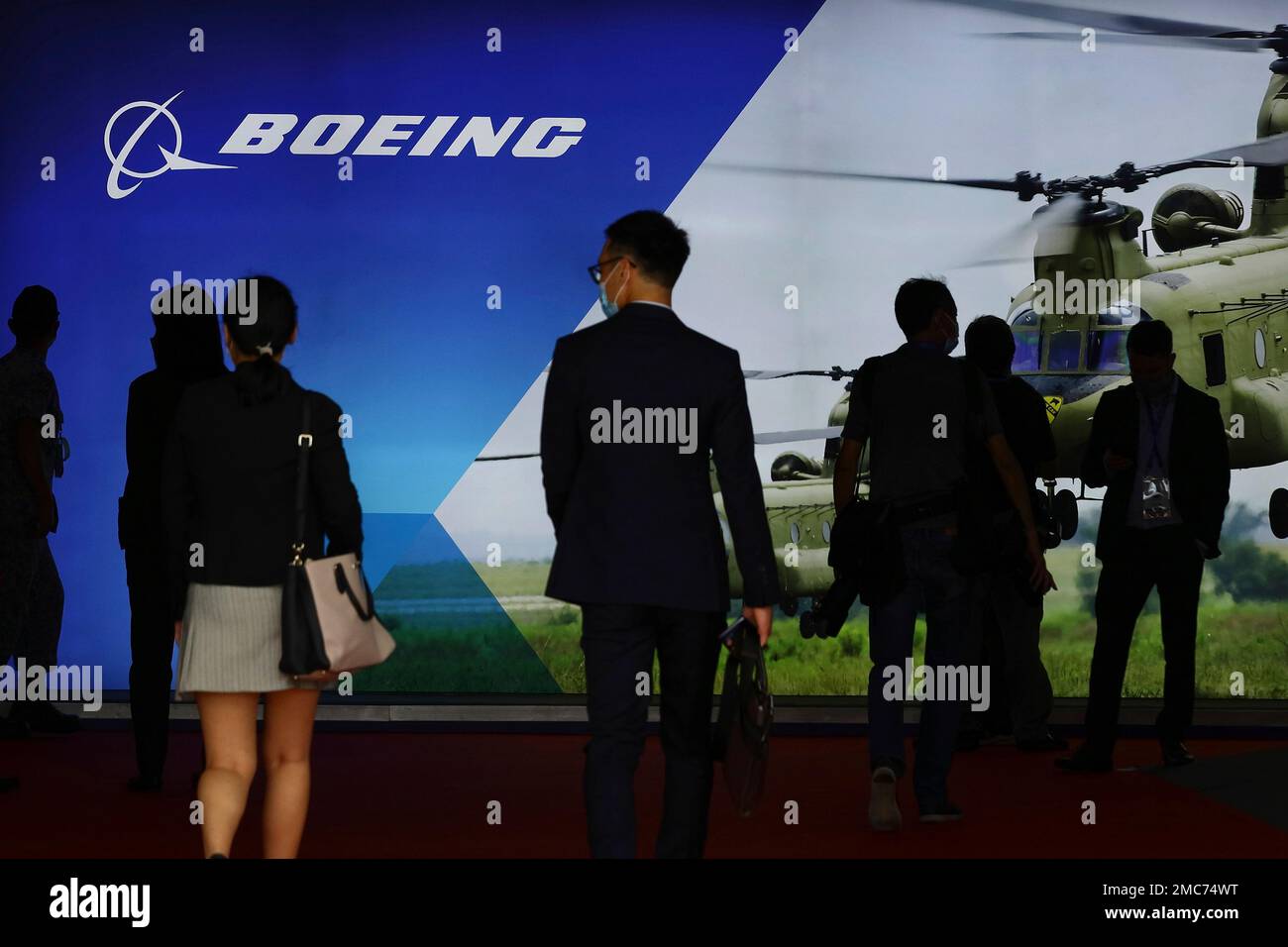 Visitors walk past the Boeing booth during the Singapore Airshow 2022 ...
