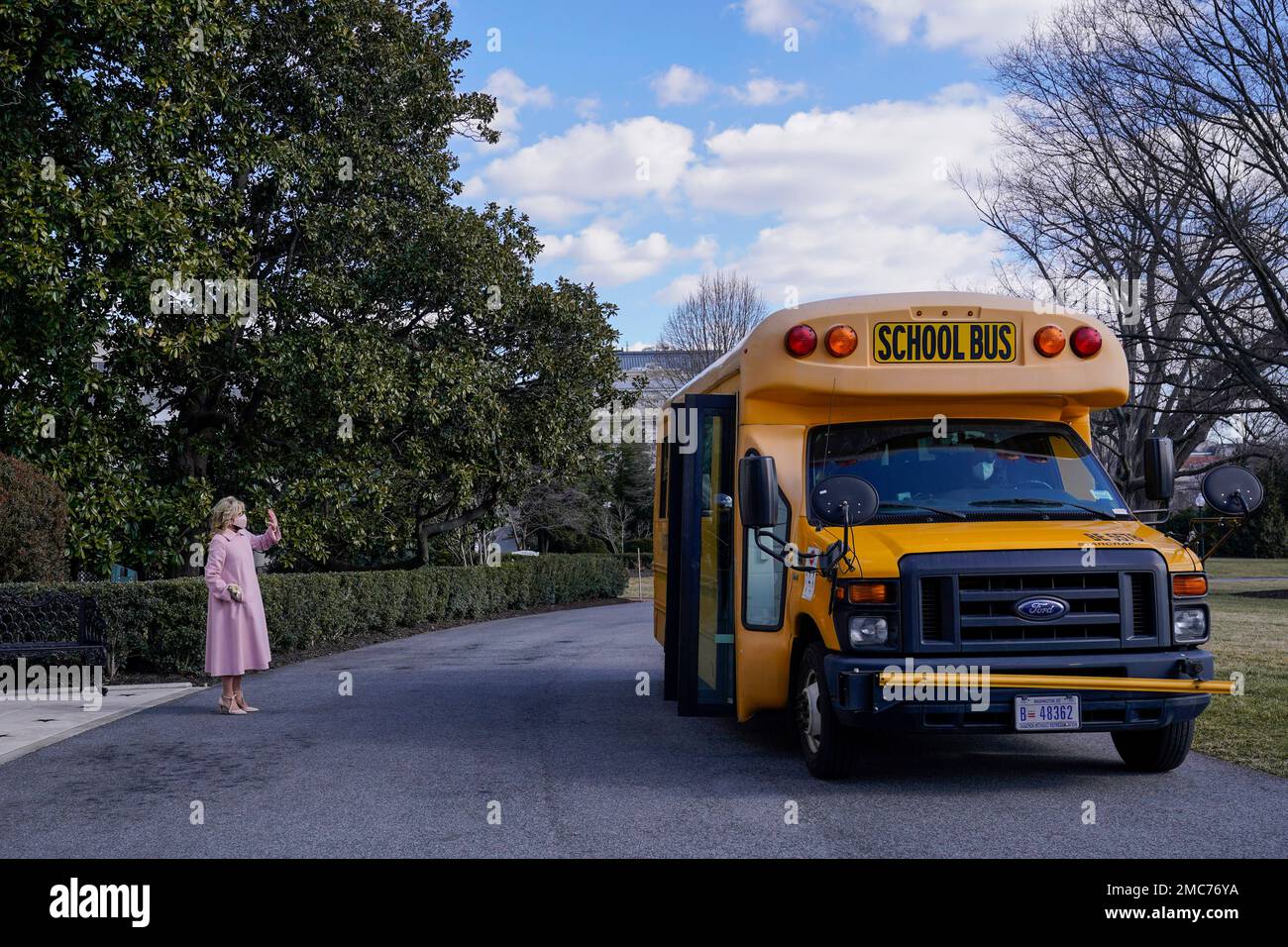 First lady Jill Biden waves as a school bus with students and staff ...