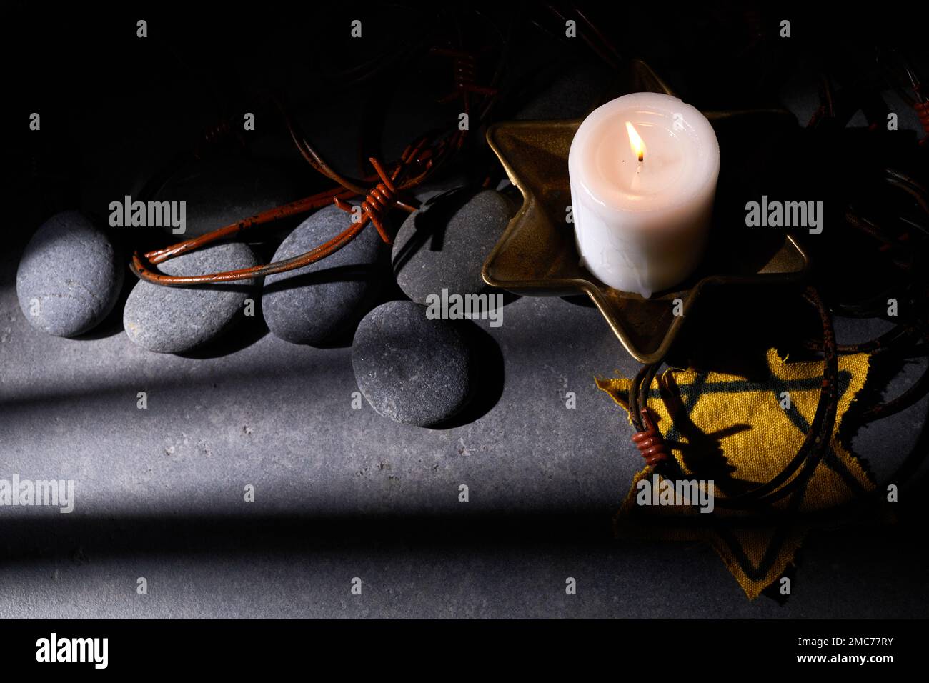 Holocaust memory day. Barbed wire, stones, yellow star and burning ...