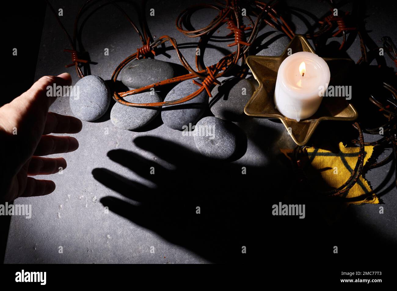 Holocaust memory day. Barbed wire, stones, yellow star and burning ...