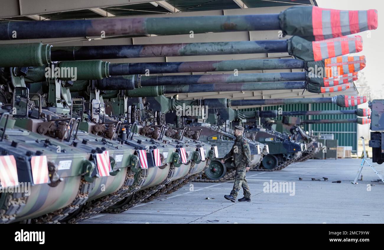 German soldiers walk beside tank howitzers prior transport to Lithuania ...