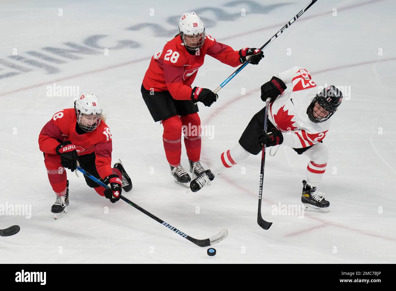 Switzerland's Stefanie Wetli (18) reaches fo the puck in front of ...
