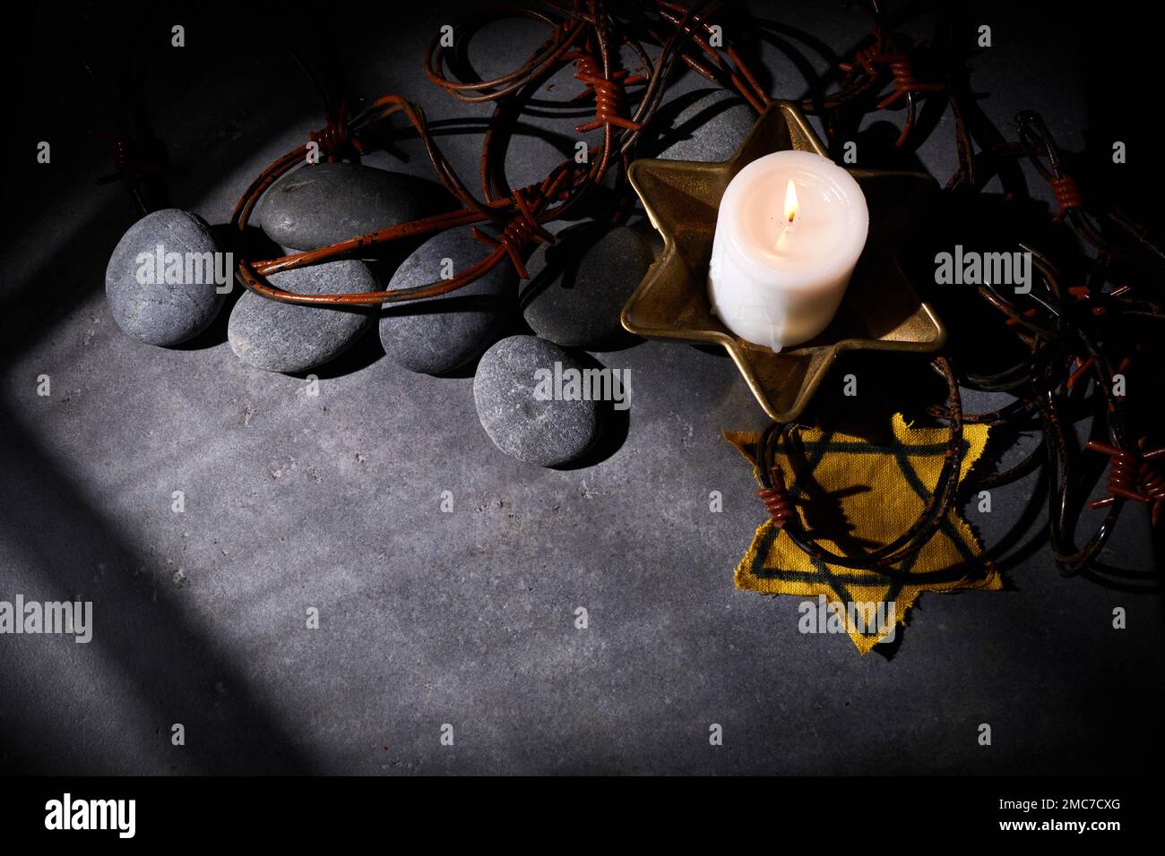 Holocaust memory day. Barbed wire, stones, yellow star and burning ...