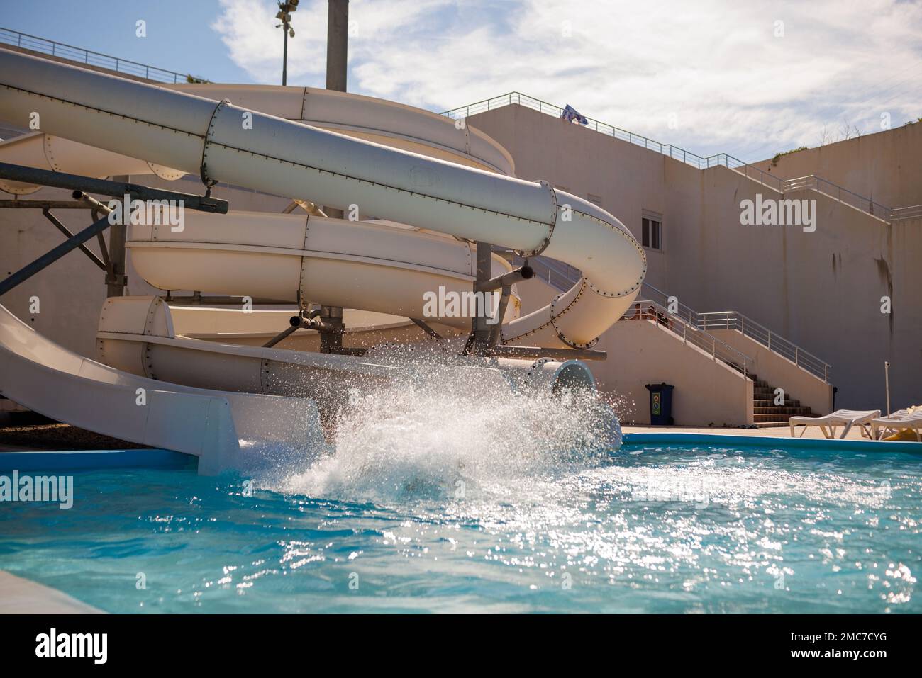 Someone unknown goes down the slide and splashes water in the pool in ...
