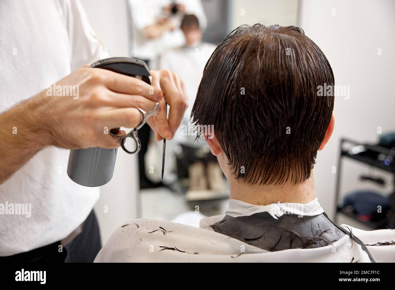 young caucasian man getting haircut by professional male hairstylist ...